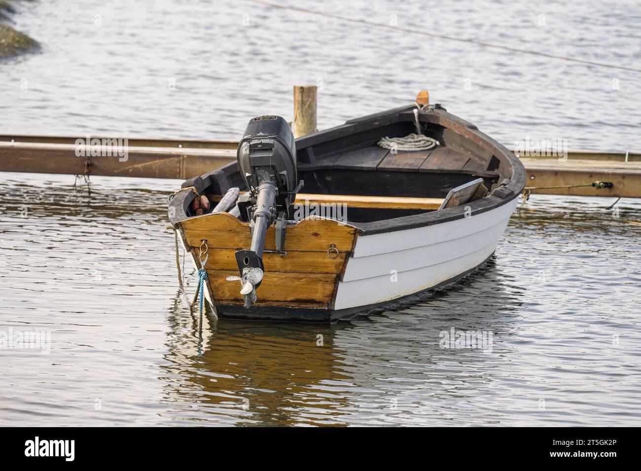 Old wooden small boat with a small outboard engine Stock Photo - Alamy