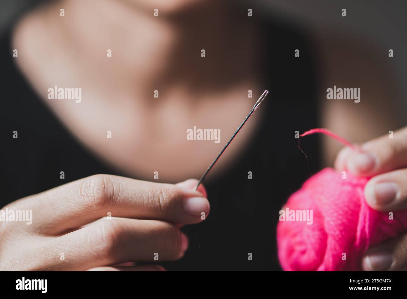 Woman fingers threading a needle Stock Photo - Alamy