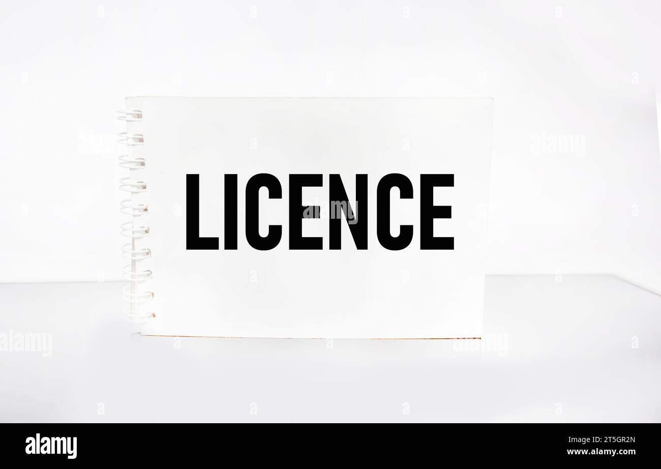 LICENSED word written on a notepad and white background Stock Photo - Alamy