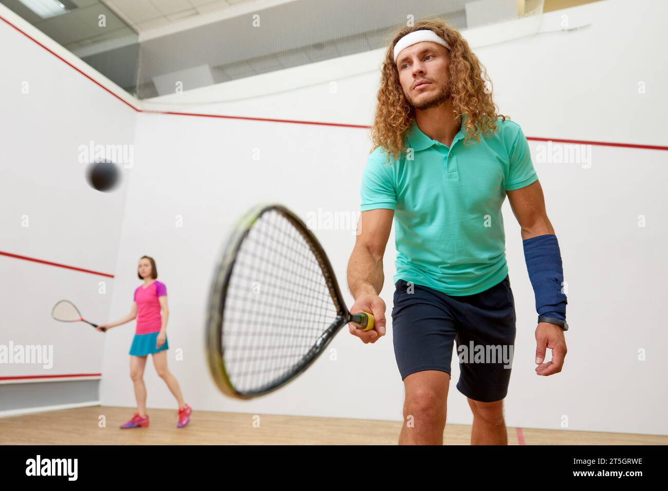 Squash male player with racket playing game with female friend Stock ...
