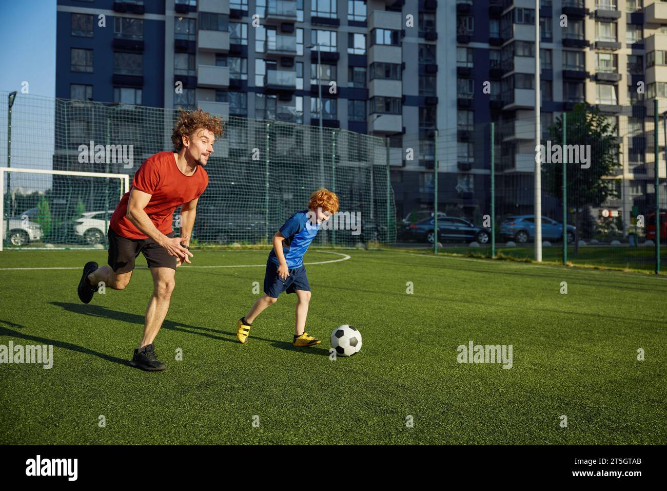 Dad and son playing soccer on field, friendly confrontation of parent ...