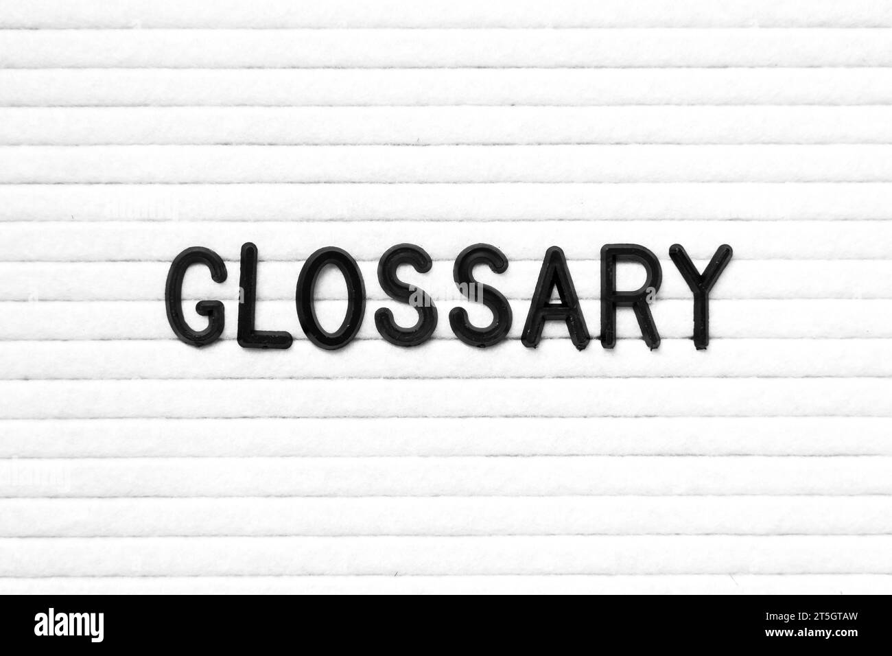 Black color letter in word glossary on white felt board background ...