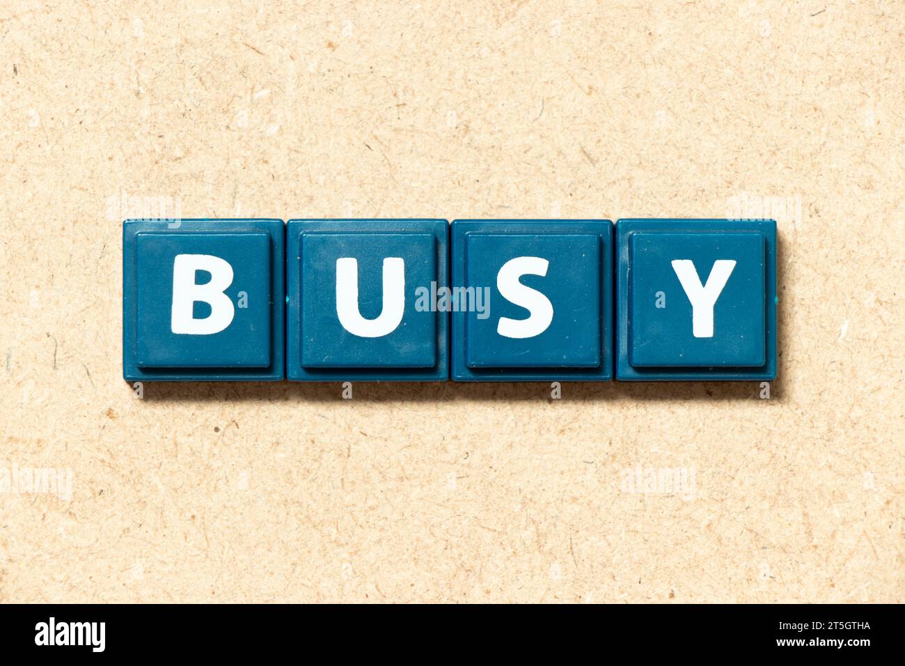 Tile alphabet letter in word busy on wood background Stock Photo - Alamy