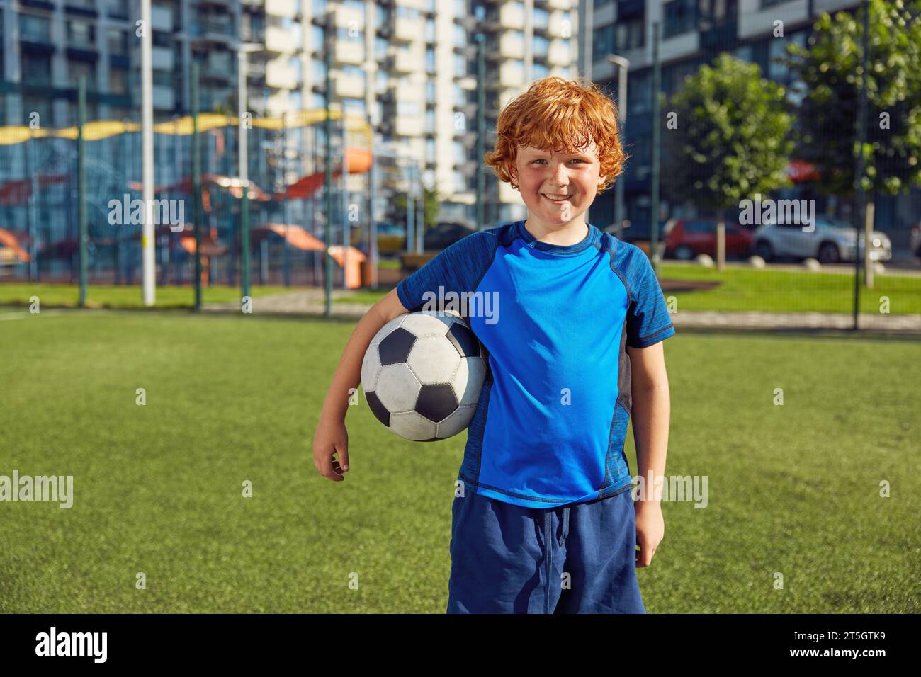 Cute redhead boy child wearing sportive uniform with soccer ball ...