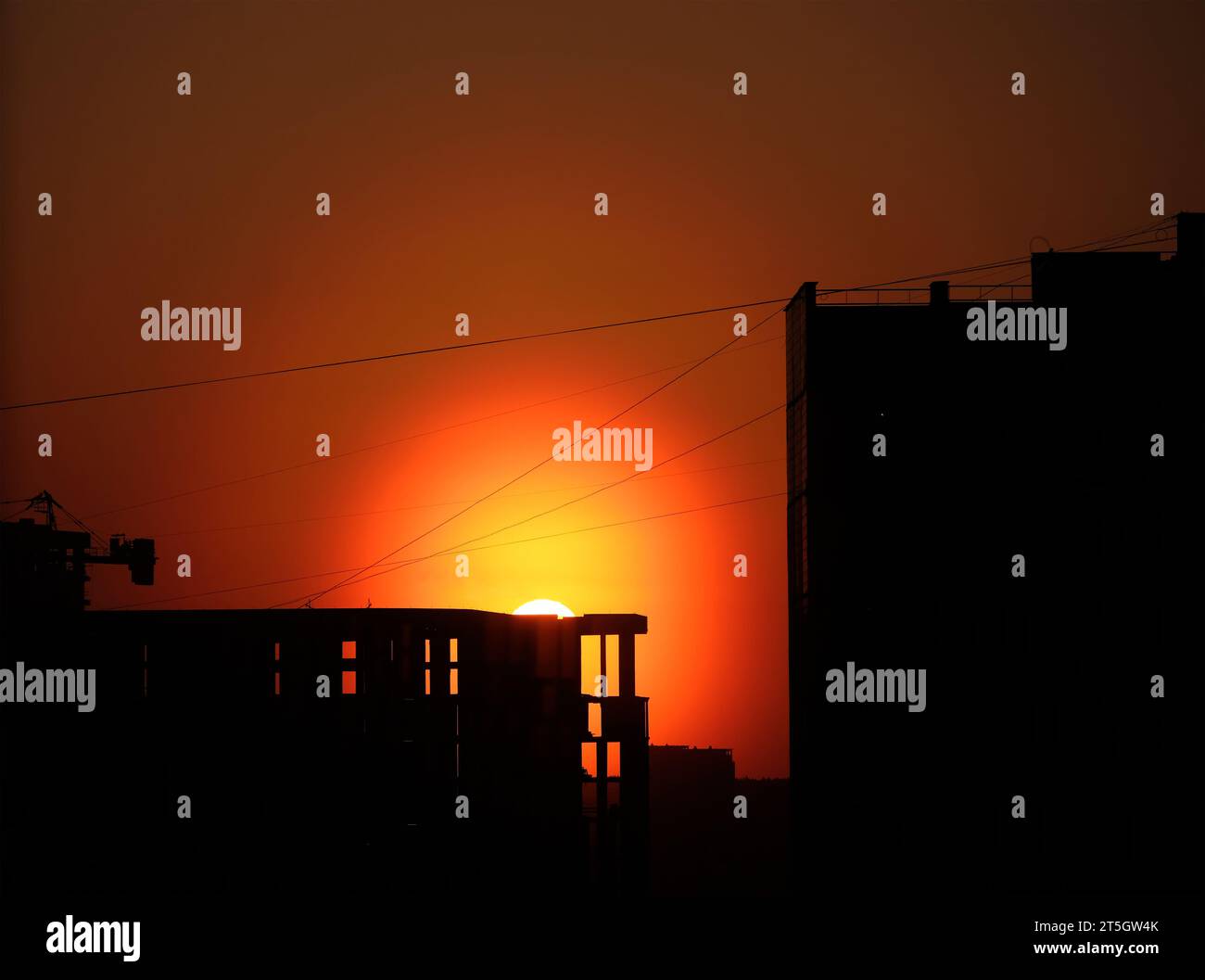 Halo effect in the evening sky, red sun on sunset in buildings ...