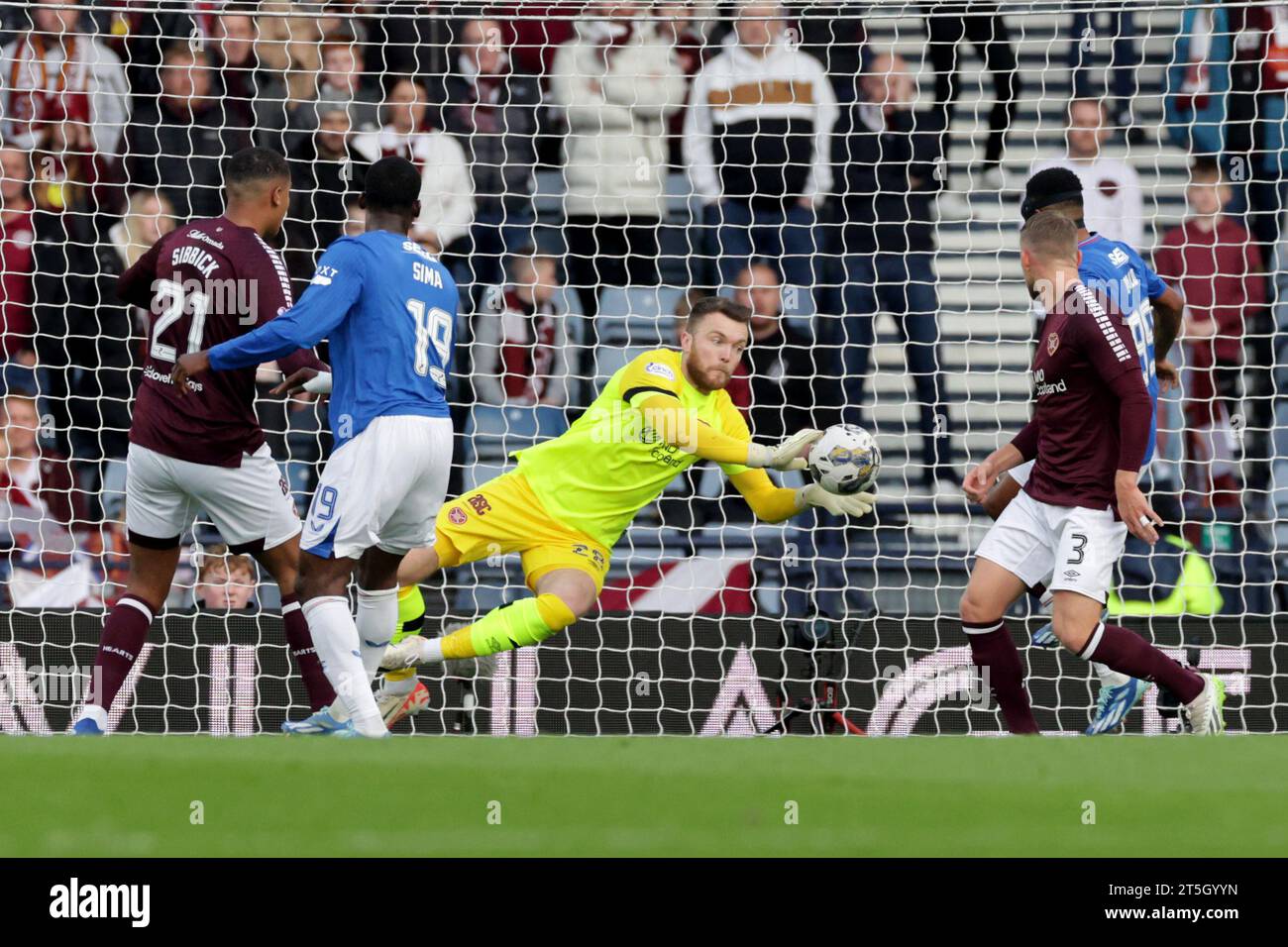 Heart of Midlothian's Zander Clark (centre) saves a shot from Rangers ...