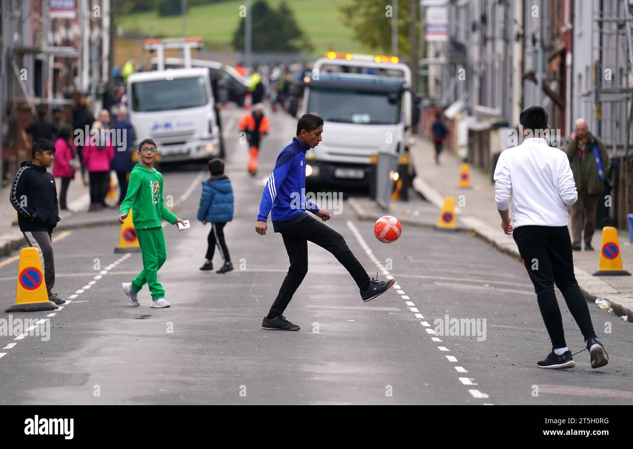Children play with a football outside the stadium ahead of the Premier ...