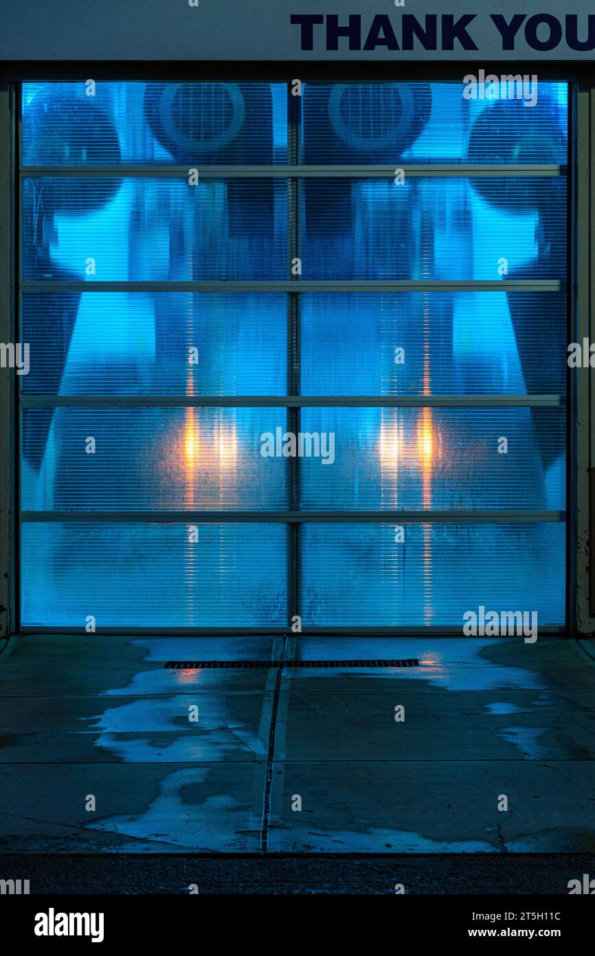 Automatic car wash exit overhead door at night Stock Photo - Alamy