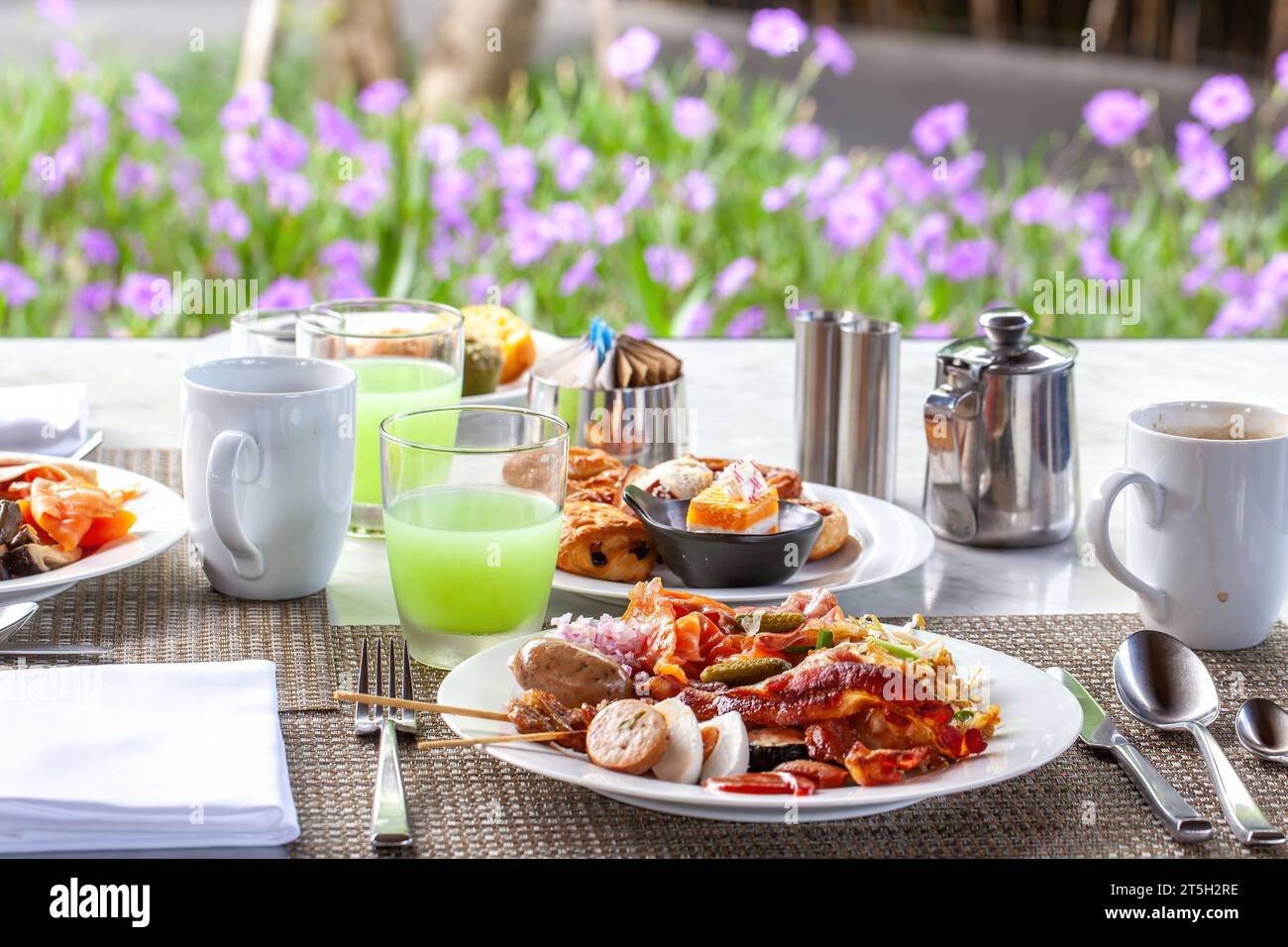 Fresh morning meal set on patio table, with greenery background Stock ...
