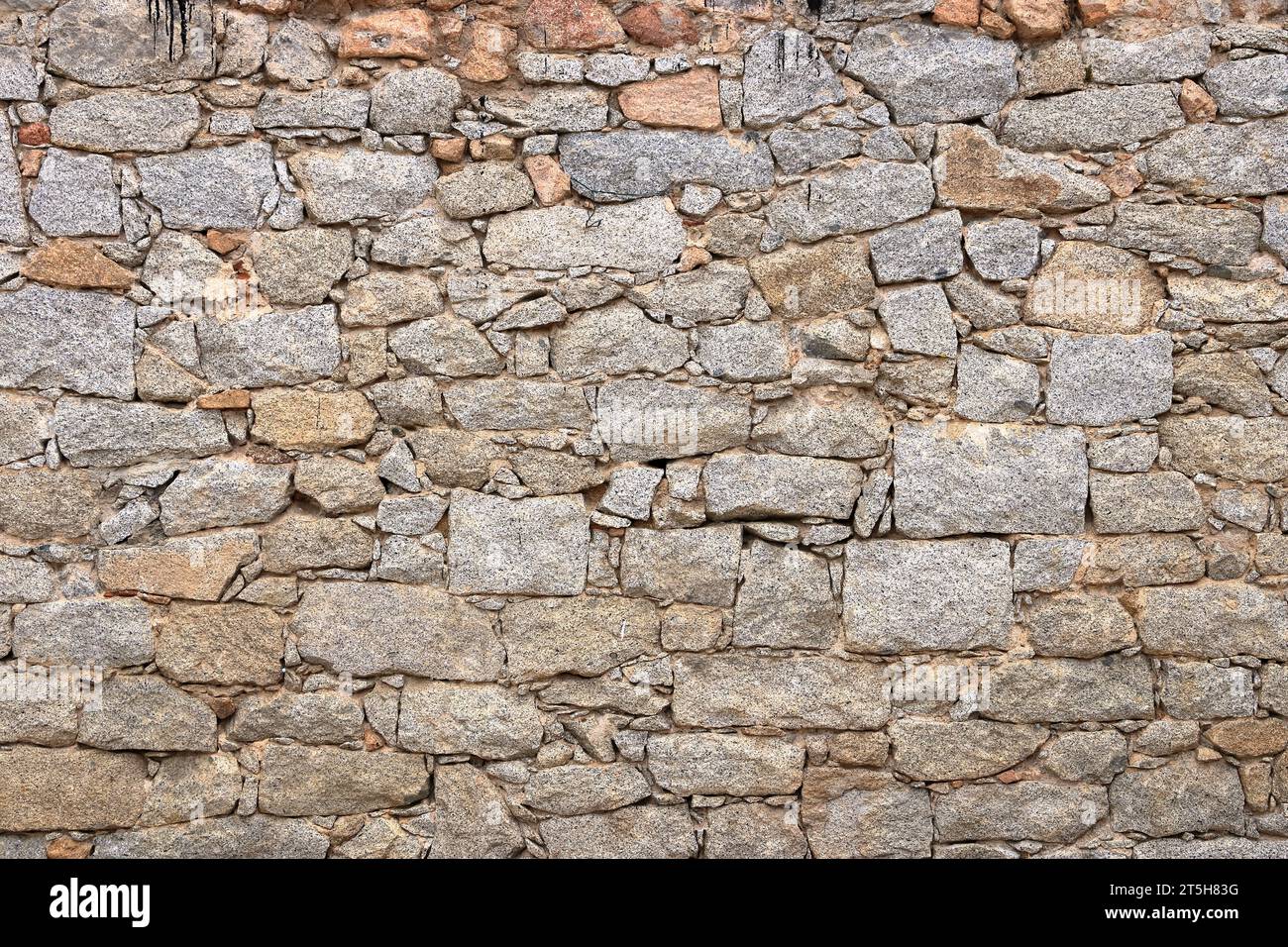 yellow beige natural stone wall of different sized stones, traditional ...
