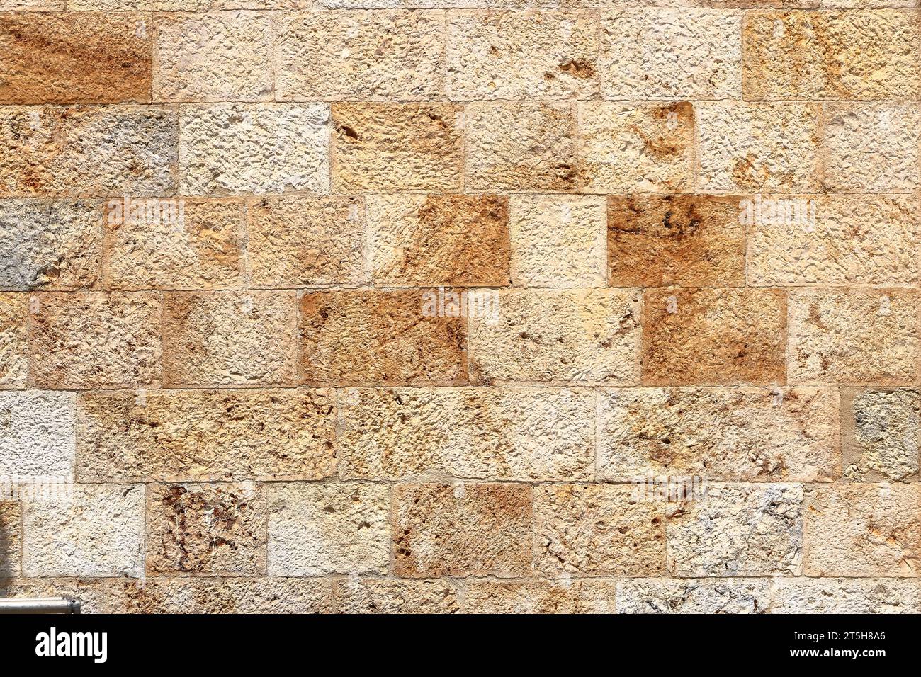 yellow beige natural stone wall of different sized stones, traditional ...
