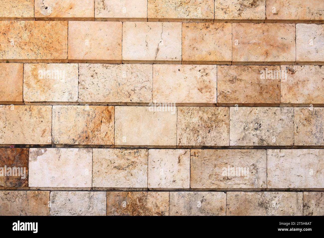 yellow beige natural stone wall of different sized stones, traditional ...