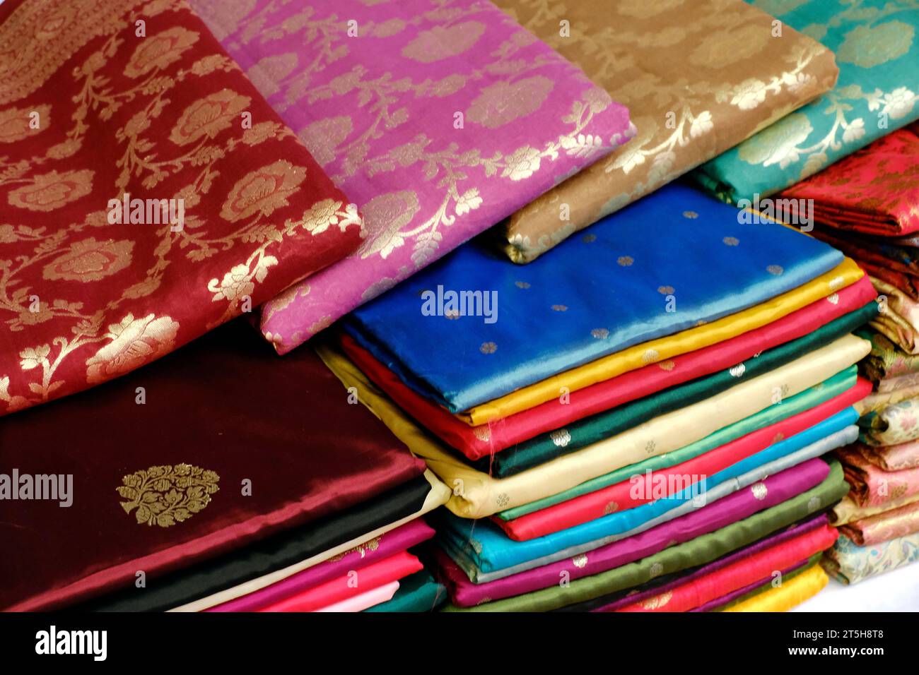 Fancy Indian sarees, Neatly stacked colorful silk saris in racks in a ...