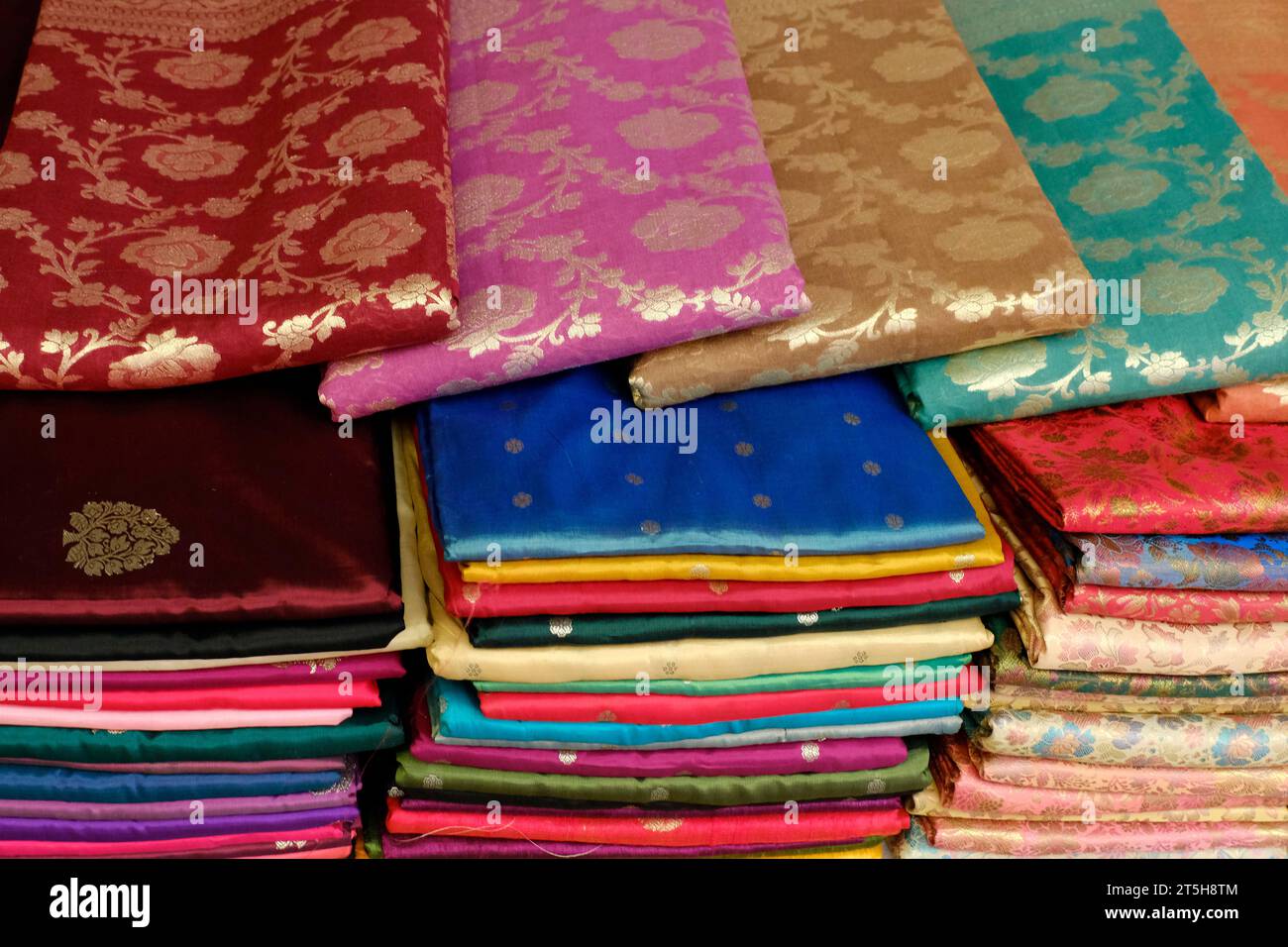 Fancy Indian sarees, Neatly stacked colorful silk saris in racks in a ...