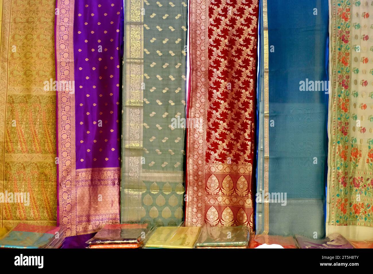 Fancy Indian sarees, Neatly stacked colorful silk saris in racks in a ...