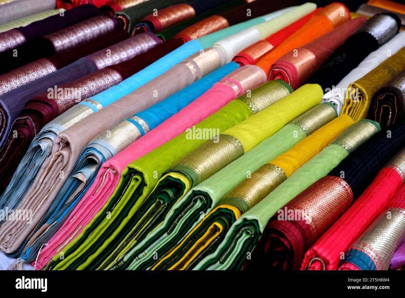Fancy Indian sarees, Neatly stacked colorful silk saris in racks in a ...