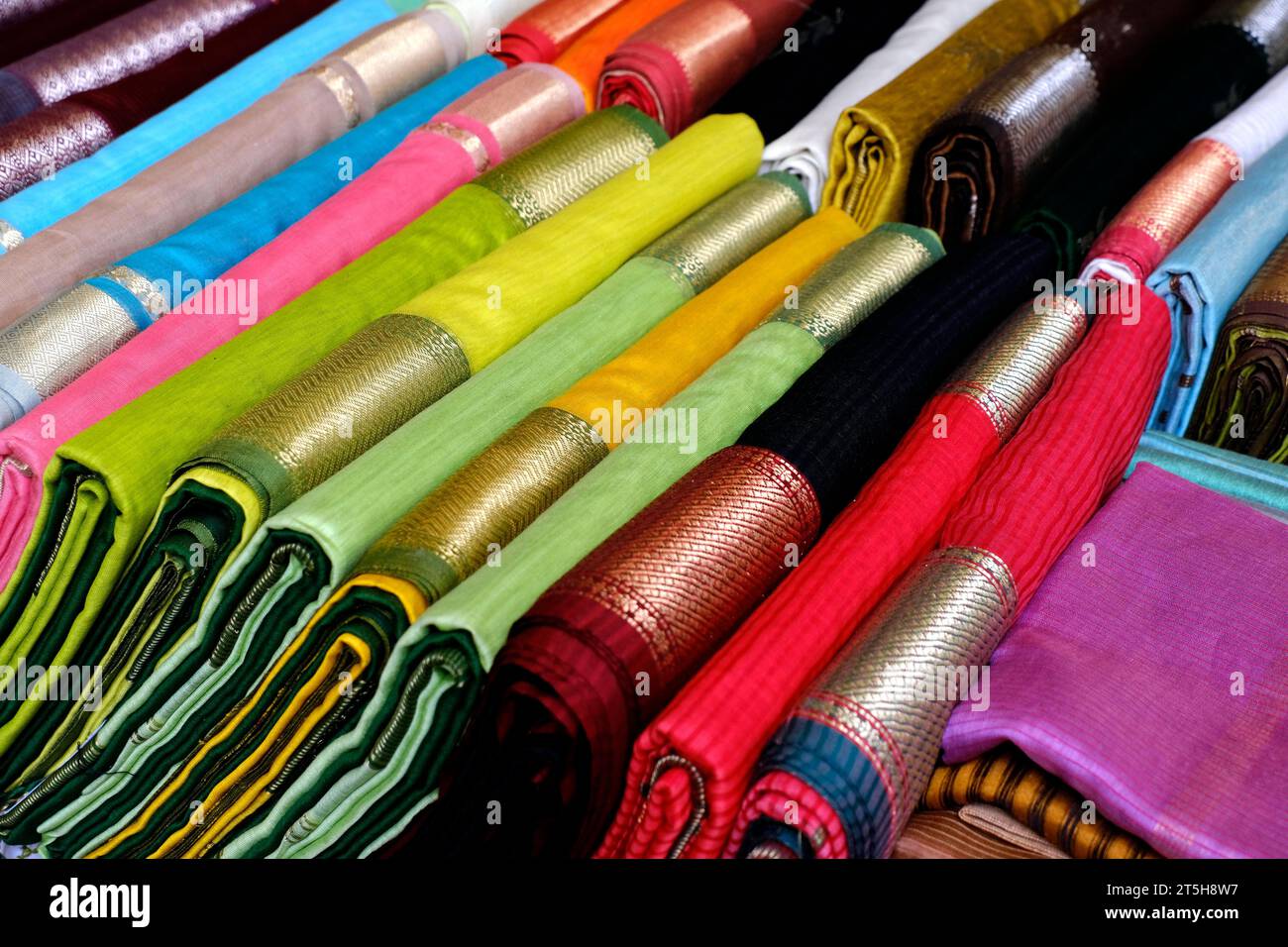 Fancy Indian sarees, Neatly stacked colorful silk saris in racks in a ...