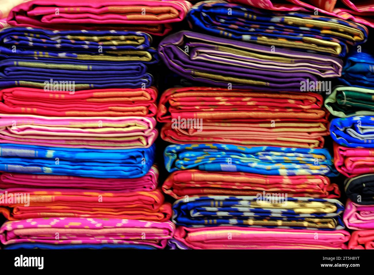 Fancy Indian sarees, Neatly stacked colorful silk saris in racks in a ...
