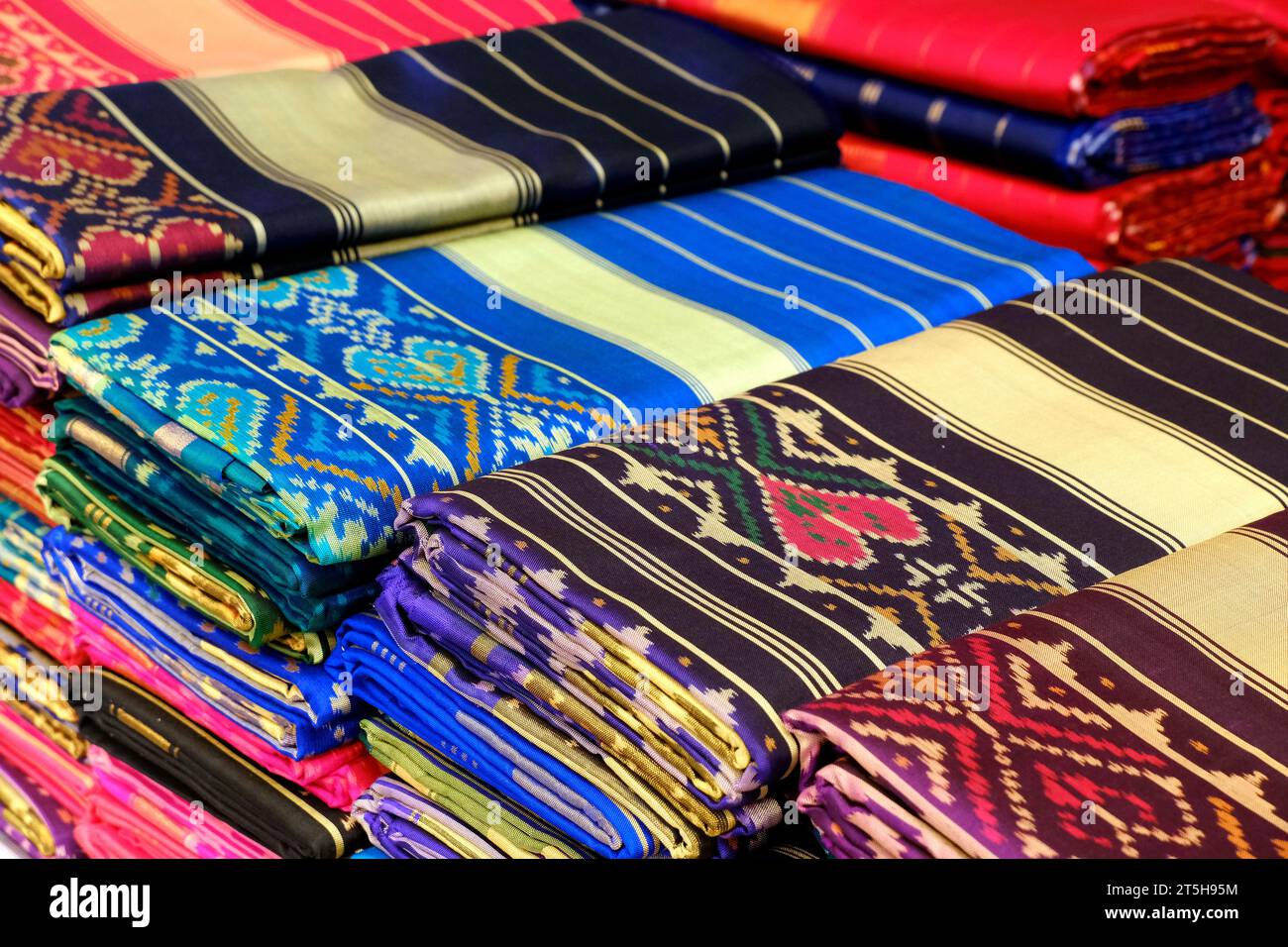 Fancy Indian sarees, Neatly stacked colorful silk saris in racks in a ...