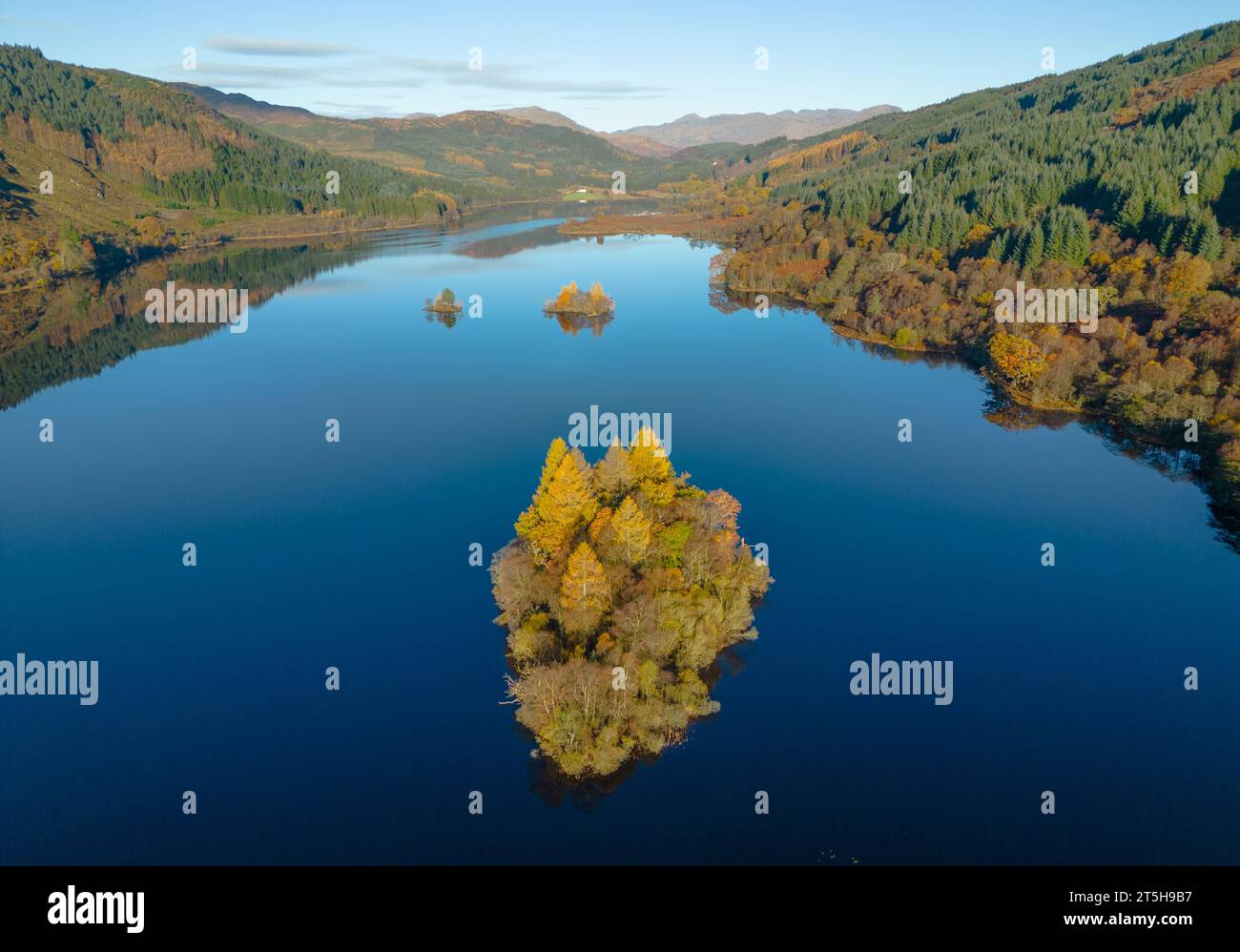Aerial view of tree covered island in autumn colours on Loch Chon ...