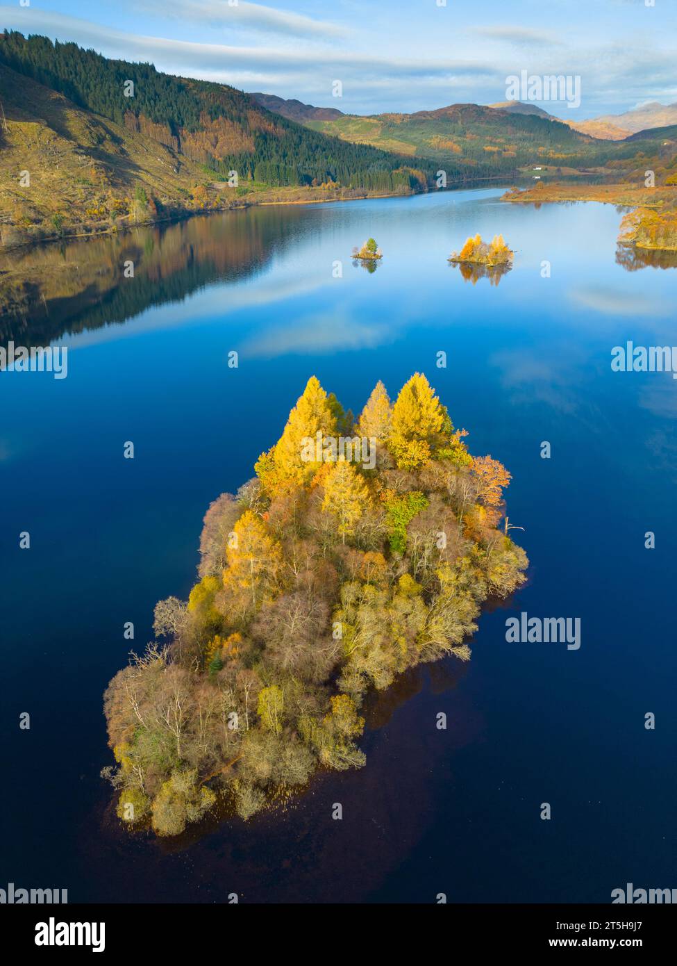 Aerial view of tree covered island in autumn colours on Loch Chon ...