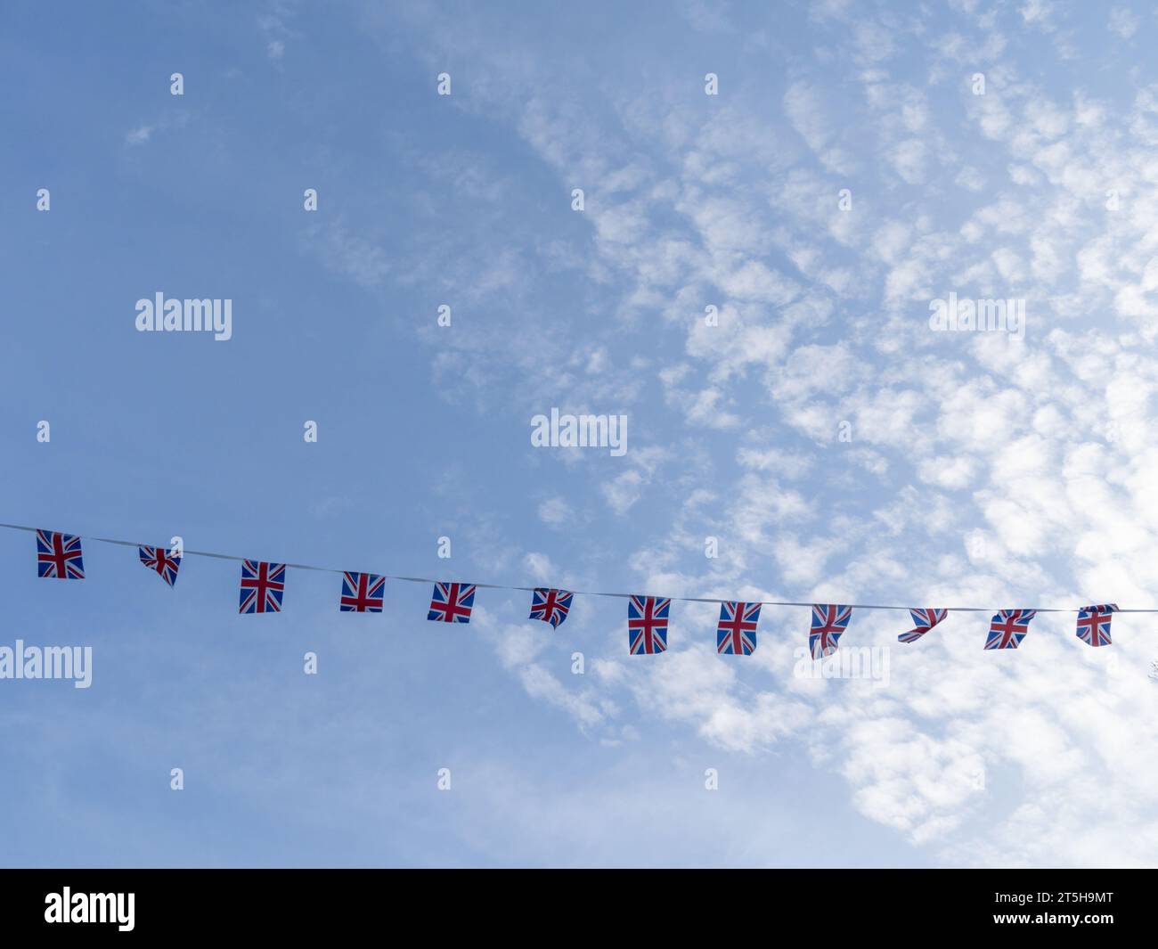 A line of Union Jack bunting flags, stretched across a summer sky Stock ...