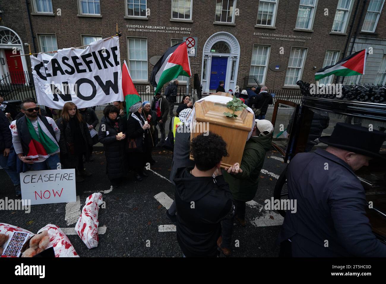 A coffin, children's shoes and effigies of dead children are delivered ...