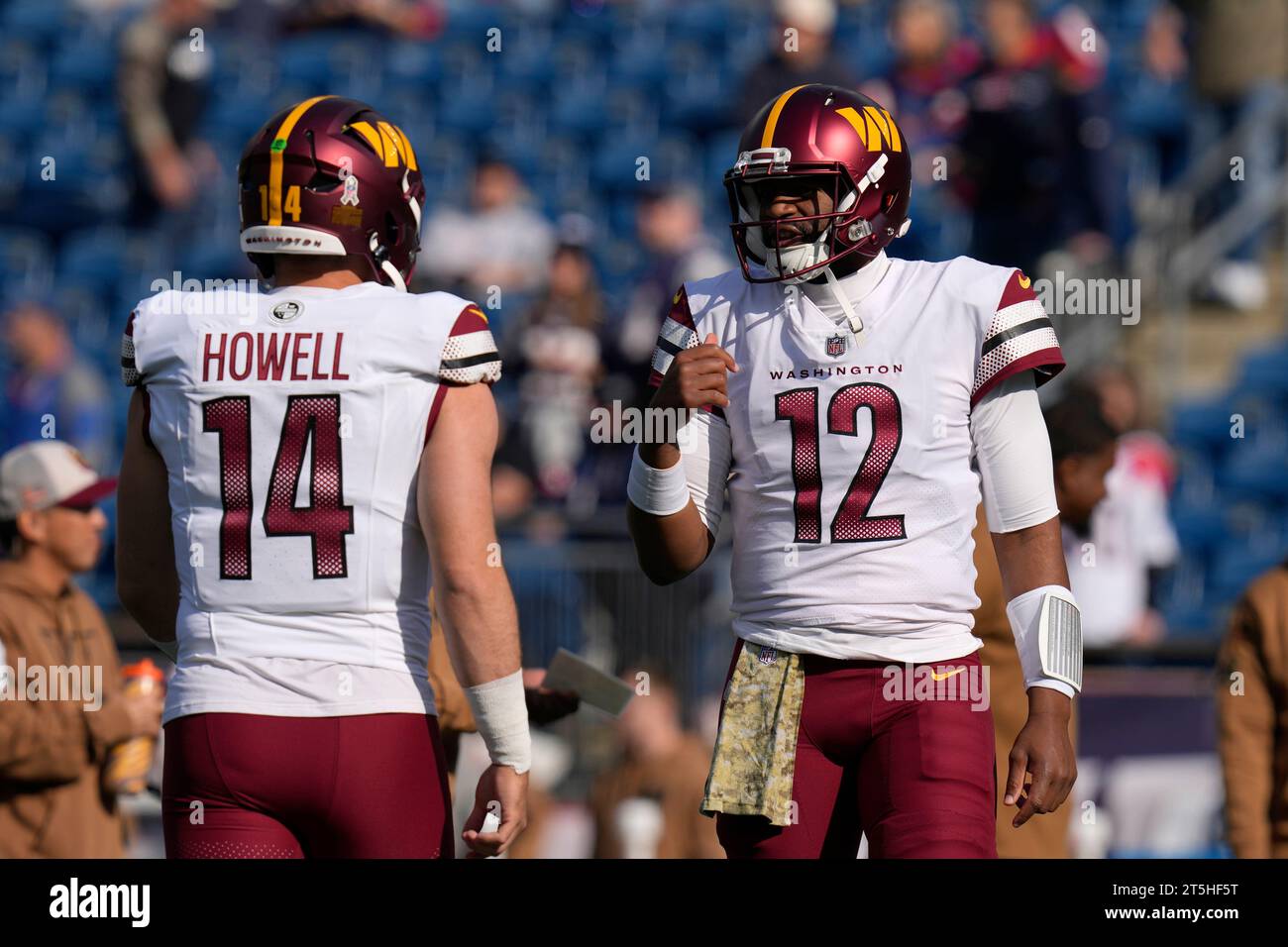 Washington Commanders quarterback Sam Howell (14) speaks with quarterback Jacoby Brissett (12 ...