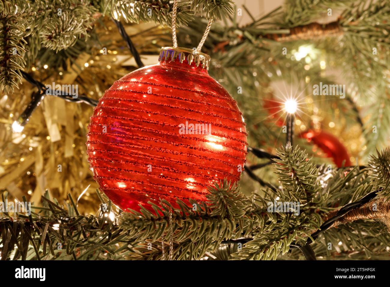Red Christmas bauble on a Christmas tree with lights Stock Photo - Alamy