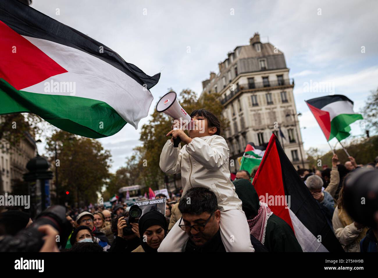 A kid chants slogans on a megaphone during the pro-palestine rally ...