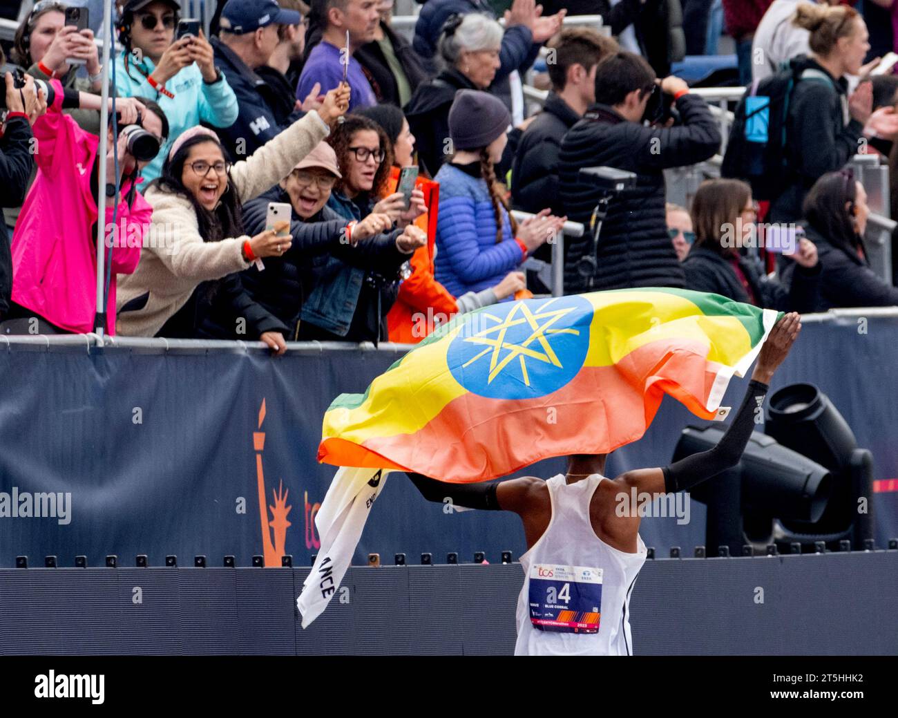 Tamirat Tola, of Ethiopia, runs past spectators with his home country's ...