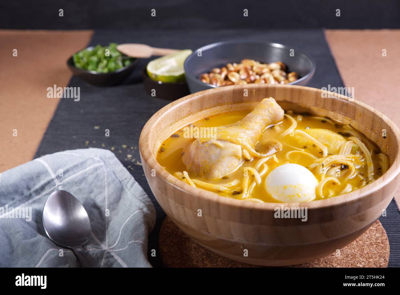 Typical Peruvian dish known as chicken soup, in a wooden bowl with ...