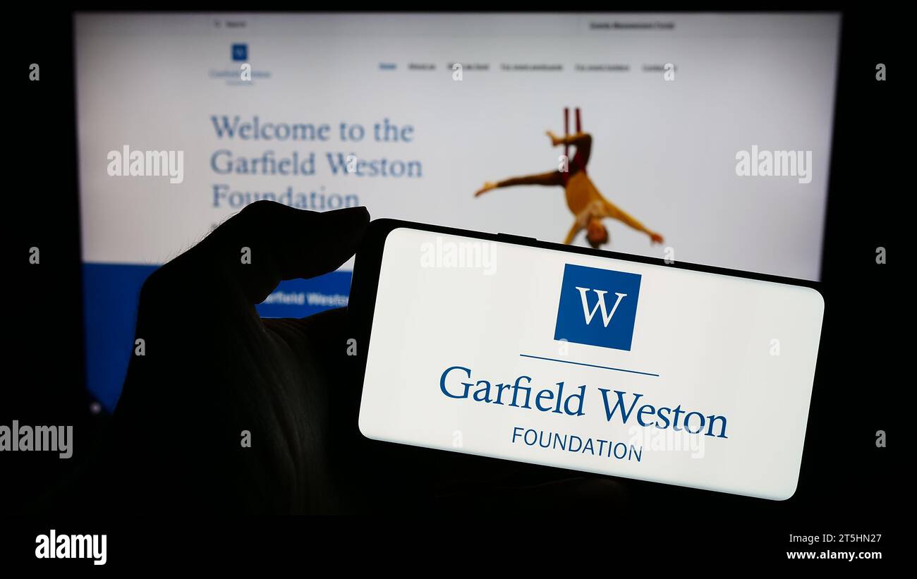Person holding cellphone with logo of British charitable organisation ...