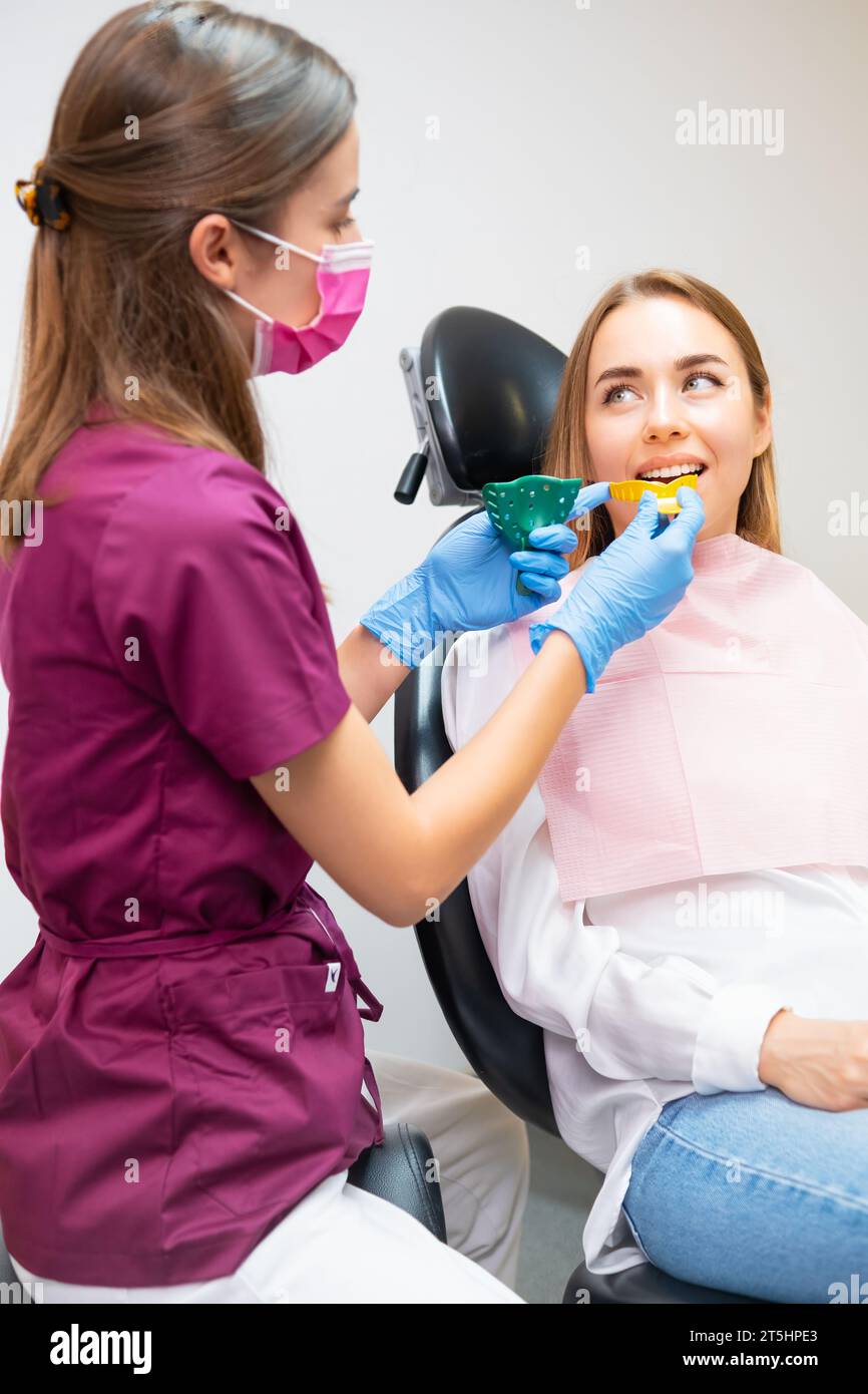 Dentist uses plastic molds to create impressions for orthodontic ...