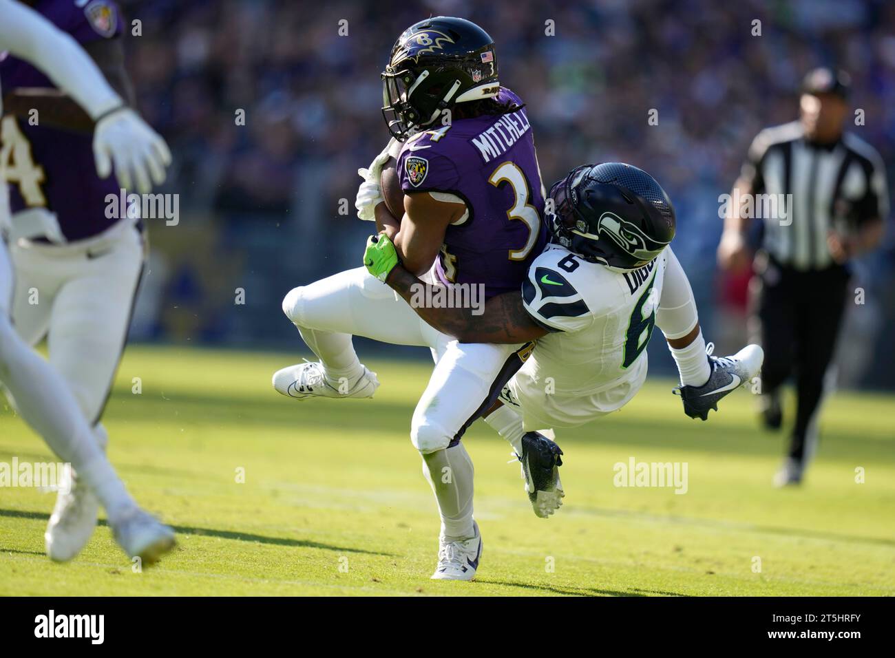 Baltimore Ravens running back Keaton Mitchell (34) is tackled by ...