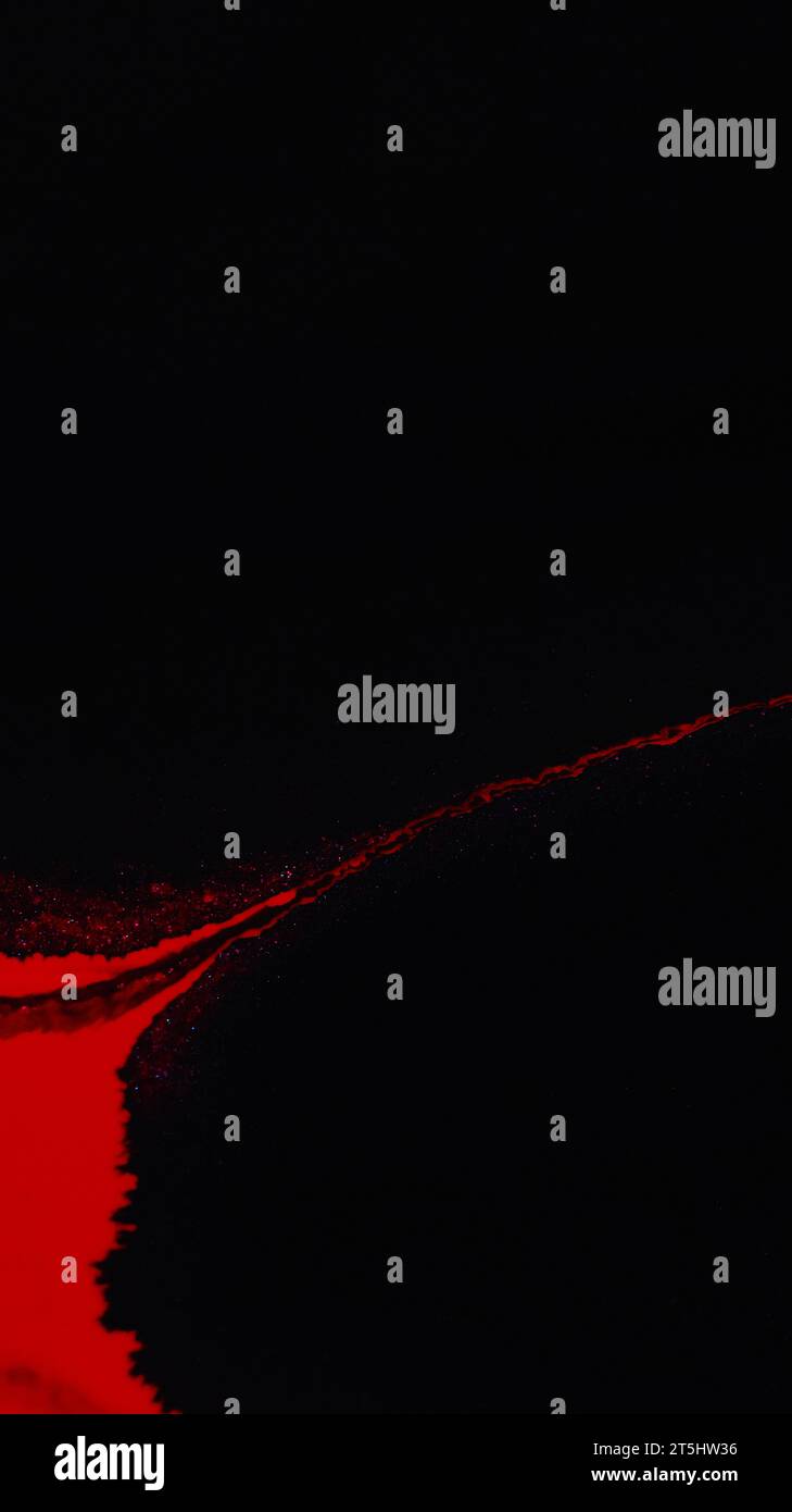 Paint pouring glitter ink spill red dye black Stock Photo - Alamy