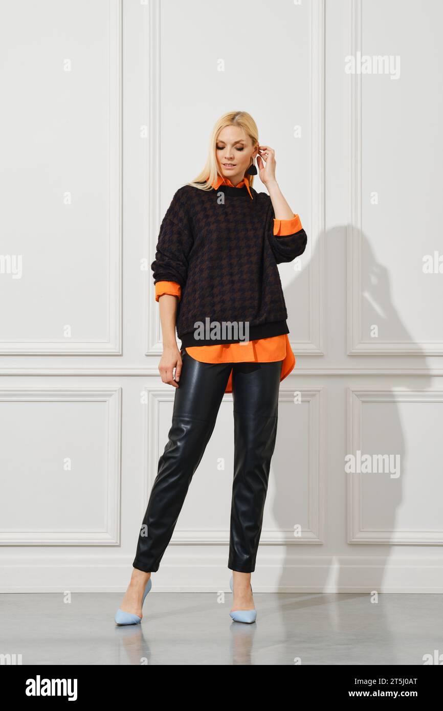 Blonde Woman In Leather Pants And A Shirt Sticking Out From Under A