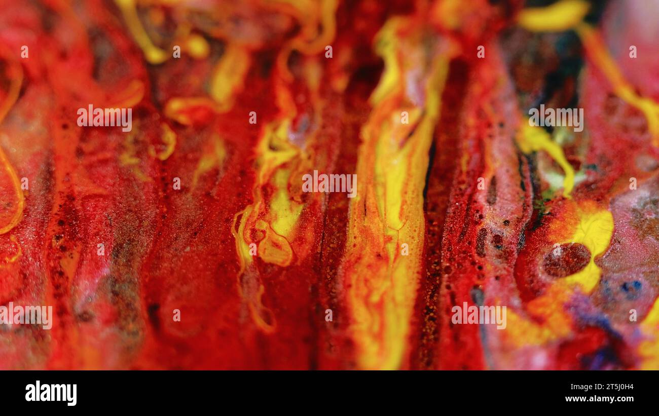 Glitter ink flow paint mix red yellow fluid wave Stock Photo - Alamy