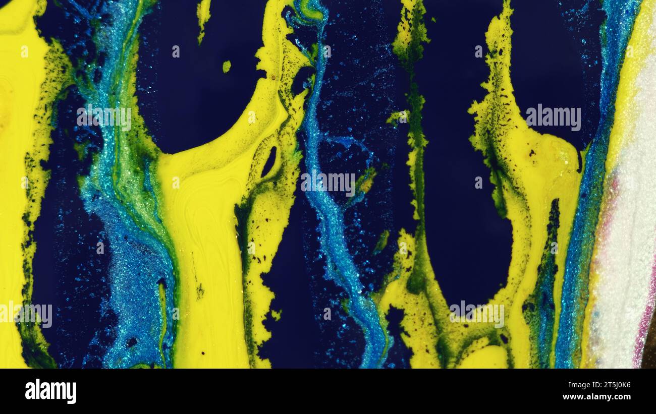 Glitter ink drip paint pouring yellow blue fluid Stock Photo - Alamy