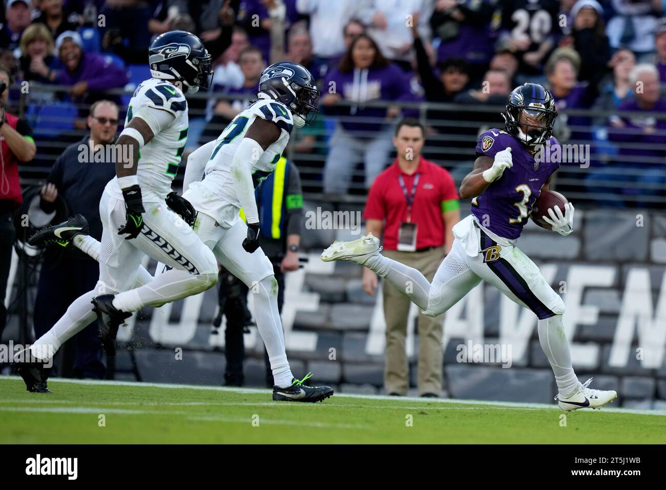 Baltimore Ravens running back Keaton Mitchell, right, runs from Seattle ...