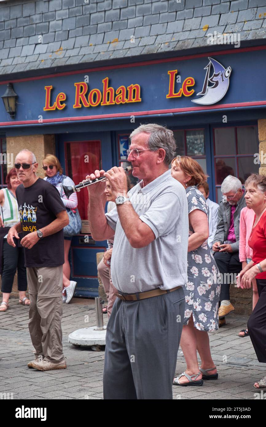 Flute player surrounded by dancing crowd on a local feast in Brittany ...