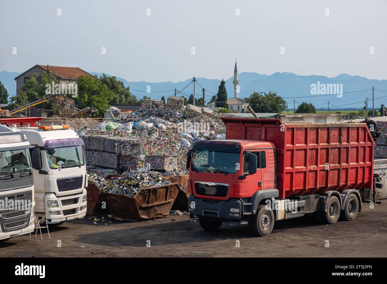 Dump trucks picking up scrap metal at recycling center in junk yard ...