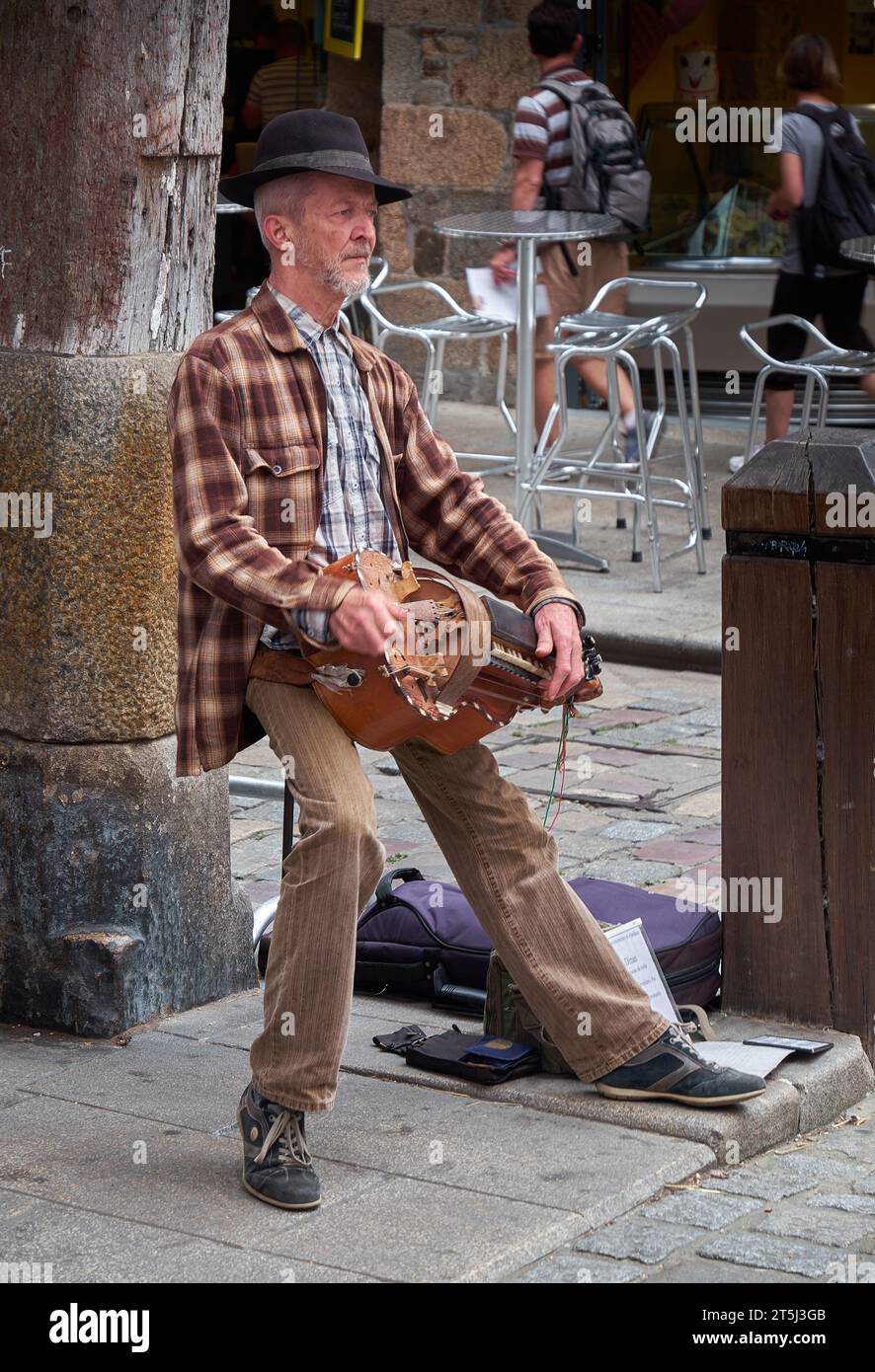 Street musician plays on an ancient musical instrument in Dinan, France ...