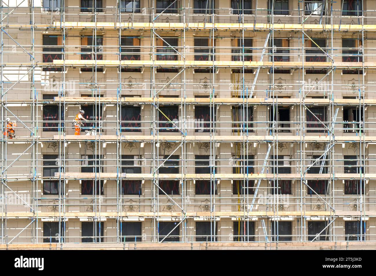 London, England, UK - 22 August 2023: Workers on scaffolding on a multi ...