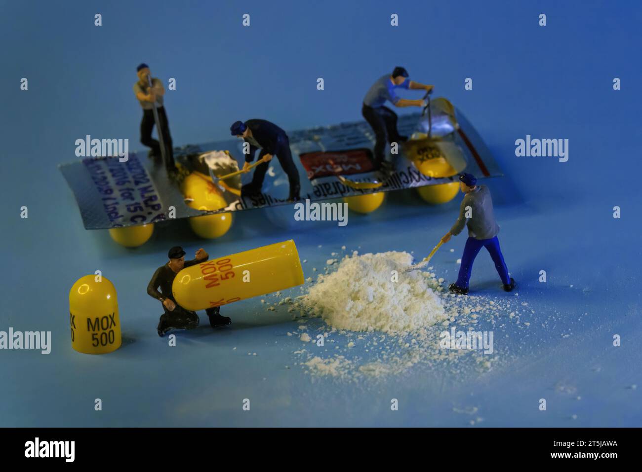 Miniature People Manufacturing Antibiotic Medication Capsules on Blue ...