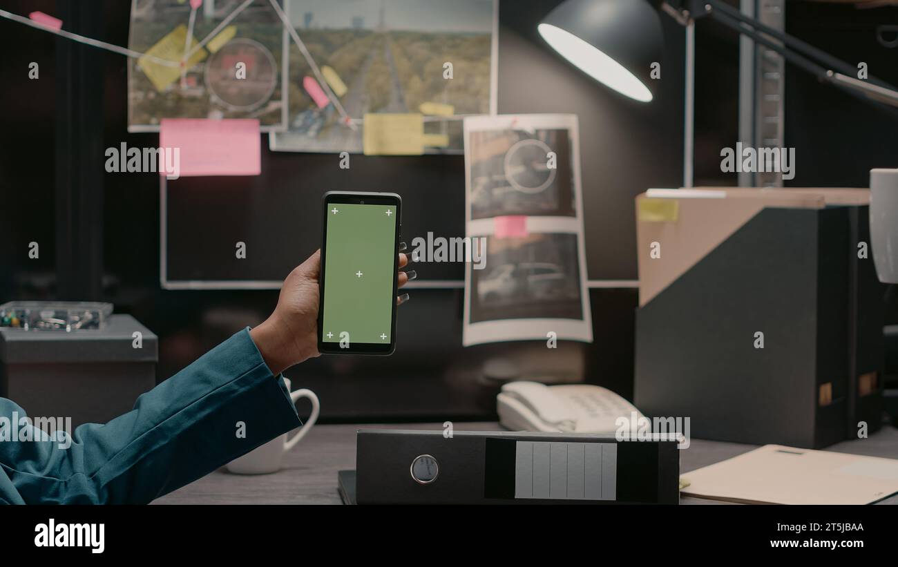 Team of police officers examining greenscreen display in private ...