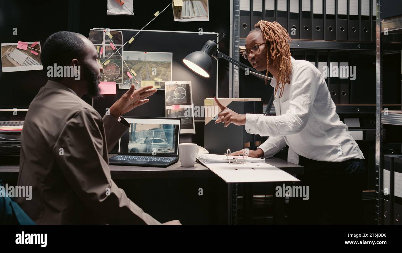 African american agents analyzing case reports in office, working on ...