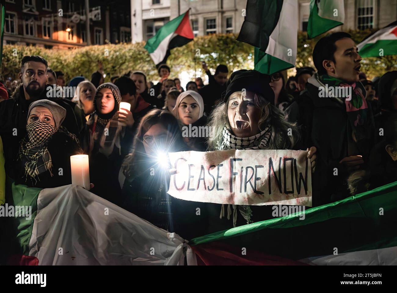 A group of people holding a banner chant slogans in support of ...