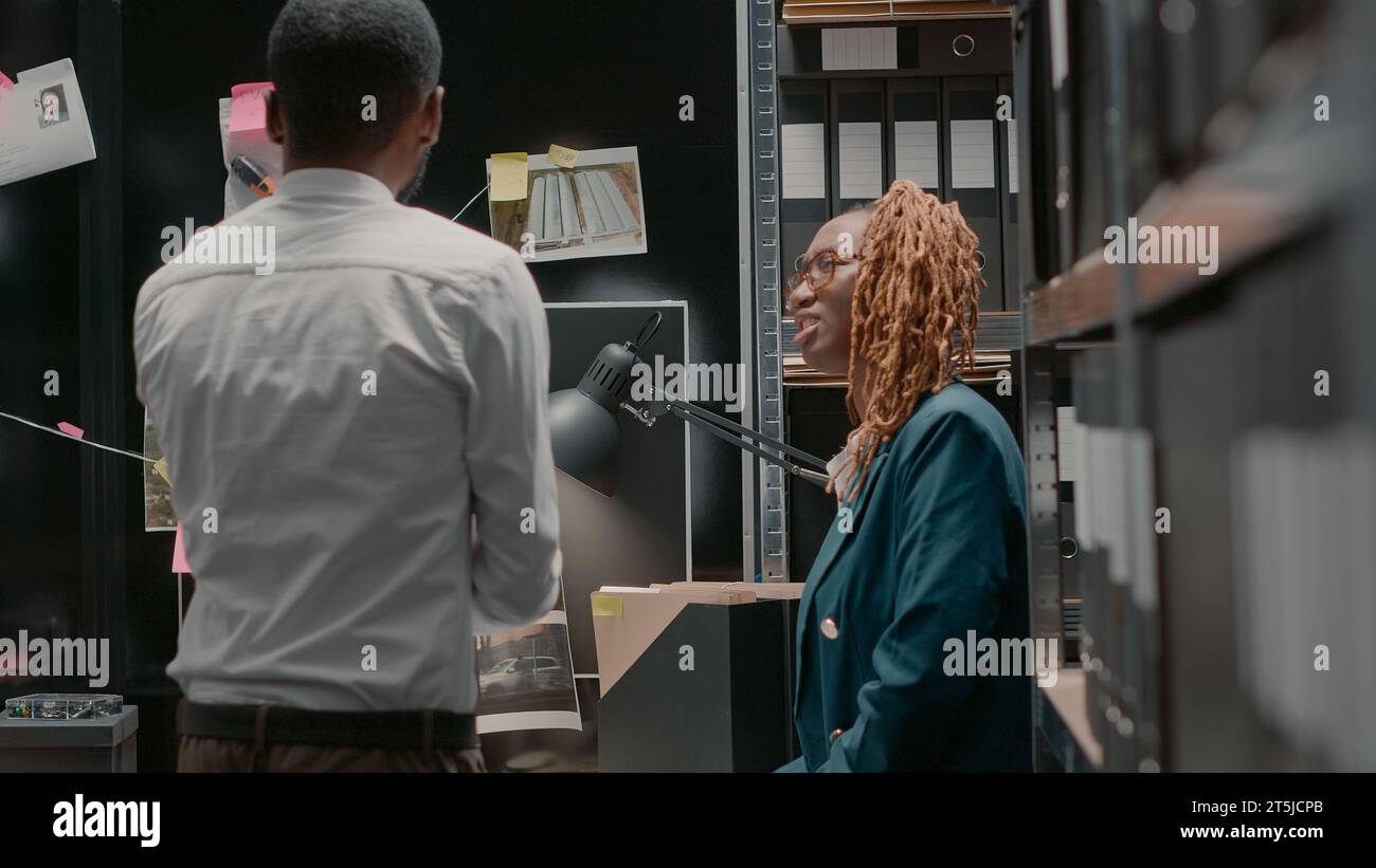 African american police team reading case clues, working in private ...