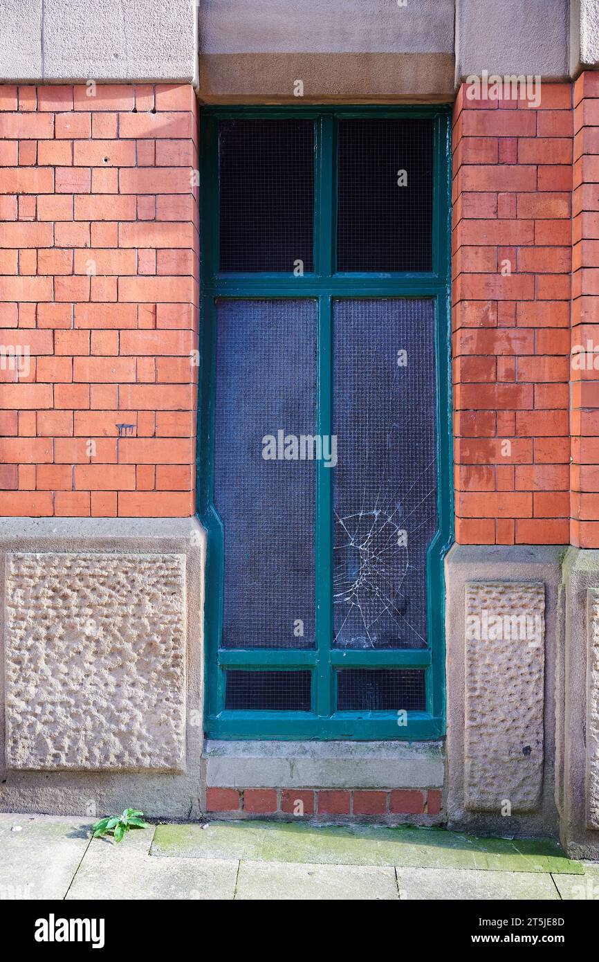 Broken window frame on outside of old red brick building in daytime ...